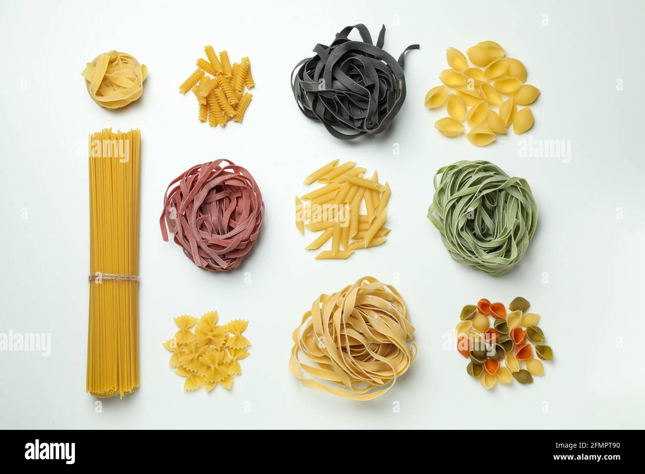 Different uncooked color pasta on white background Stock Photo - Alamy