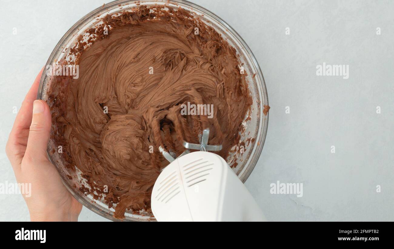 Chocolate buttercream frosting, mixing ingredients in glass bowl using ...