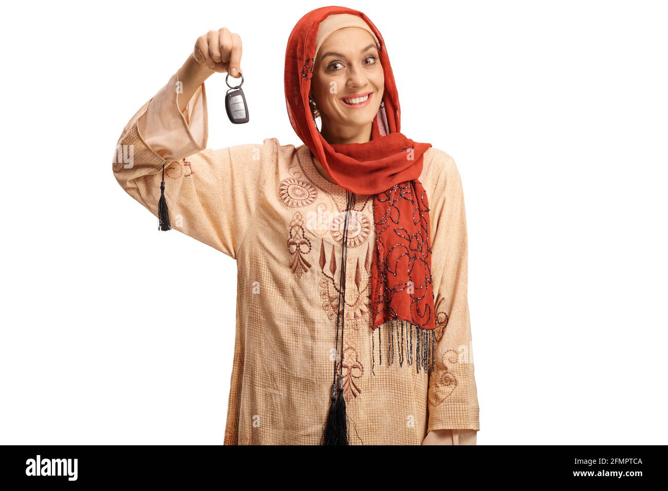 Excited muslim woman showing a car key and smiling isolated on white ...