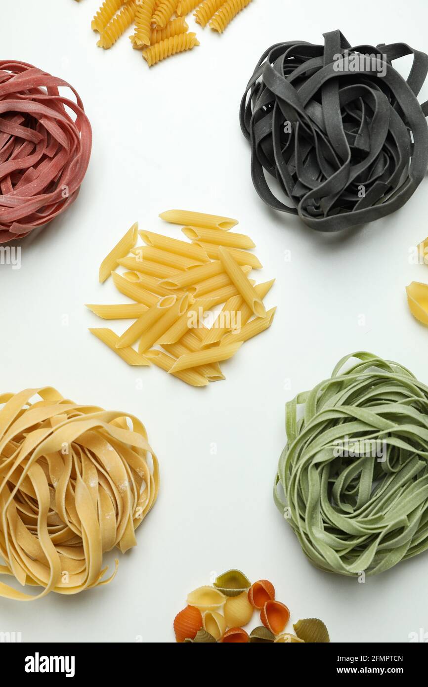 Different uncooked color pasta on white background Stock Photo - Alamy