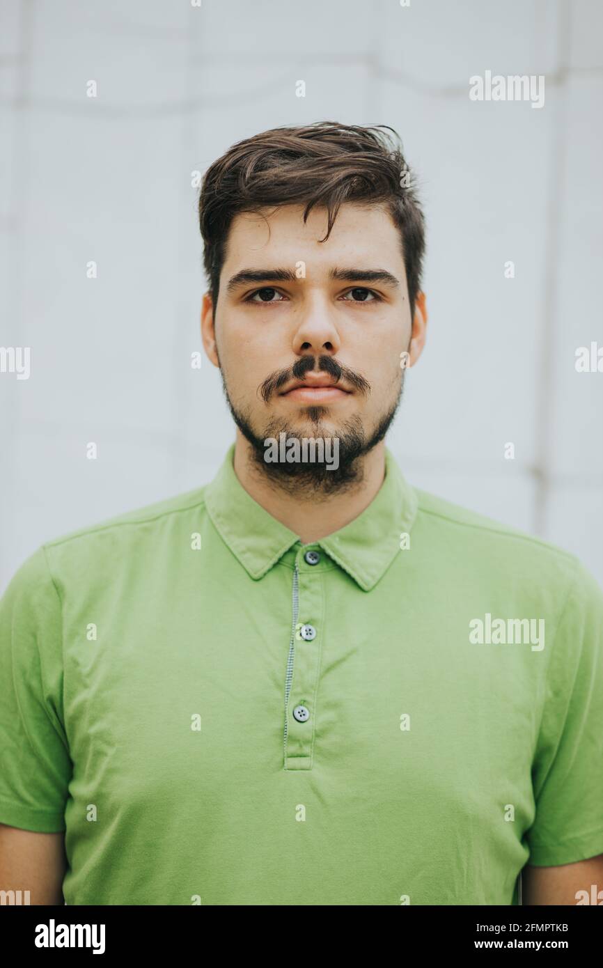 Vertical portrait of a young attractive Caucasian male with a serious ...