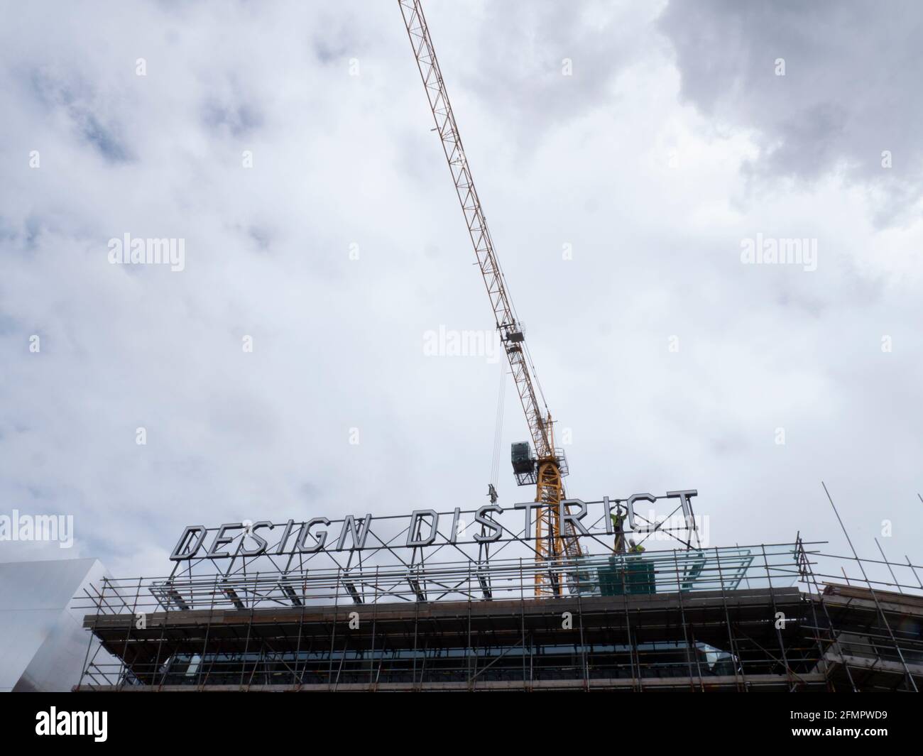 Buiders fixing Design District sign to front of building, Design ...