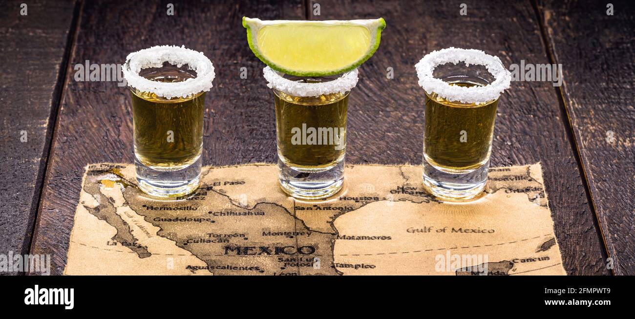 glass of gold tequila with old mexico map in the background, image ...
