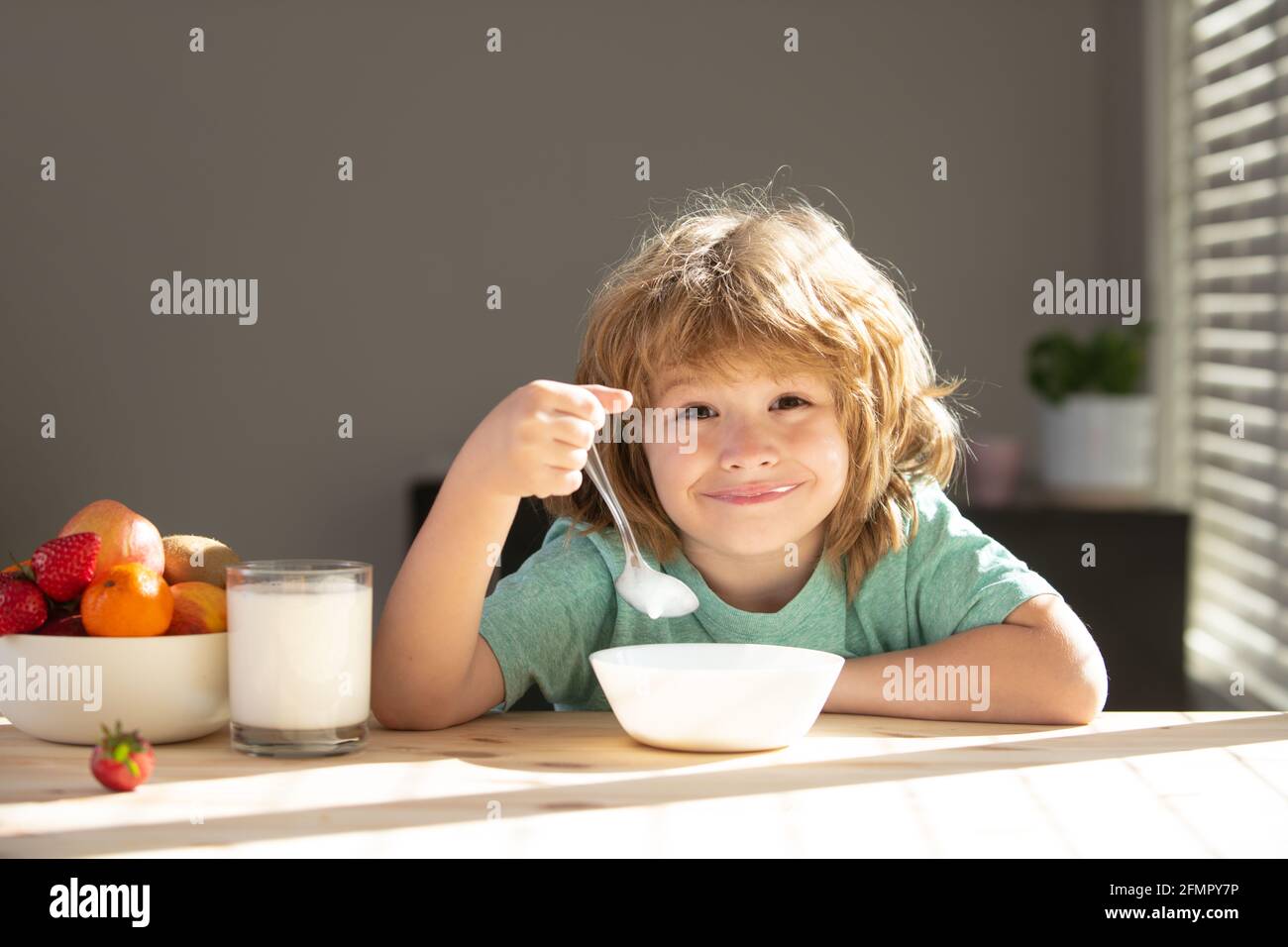 Caucasian toddler child boy eating healthy soup in the kitchen. Healthy ...