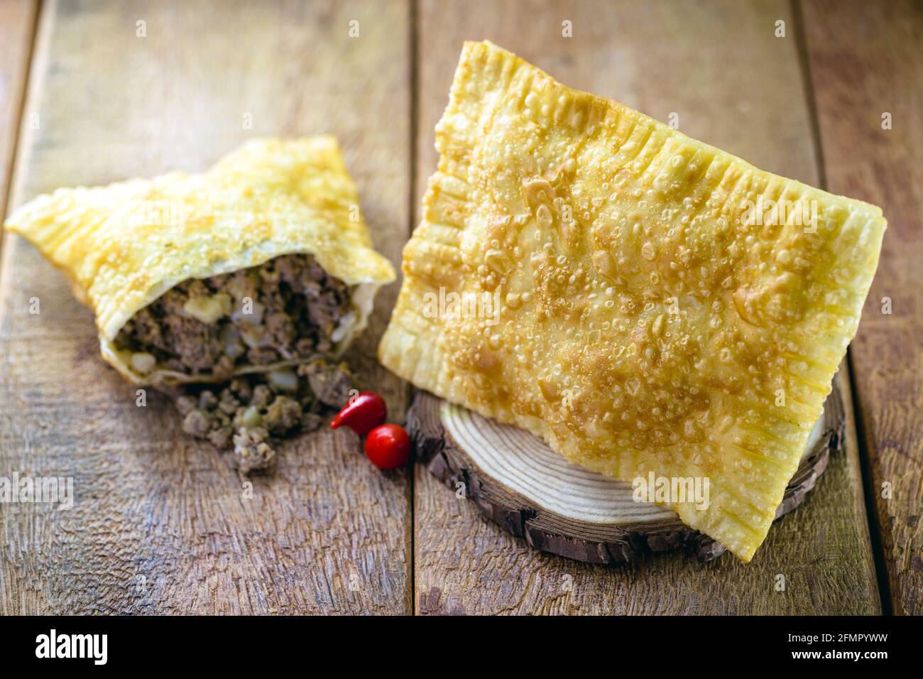 Fried pastry filled with ground meat and potatoes, hot sauce served hot ...