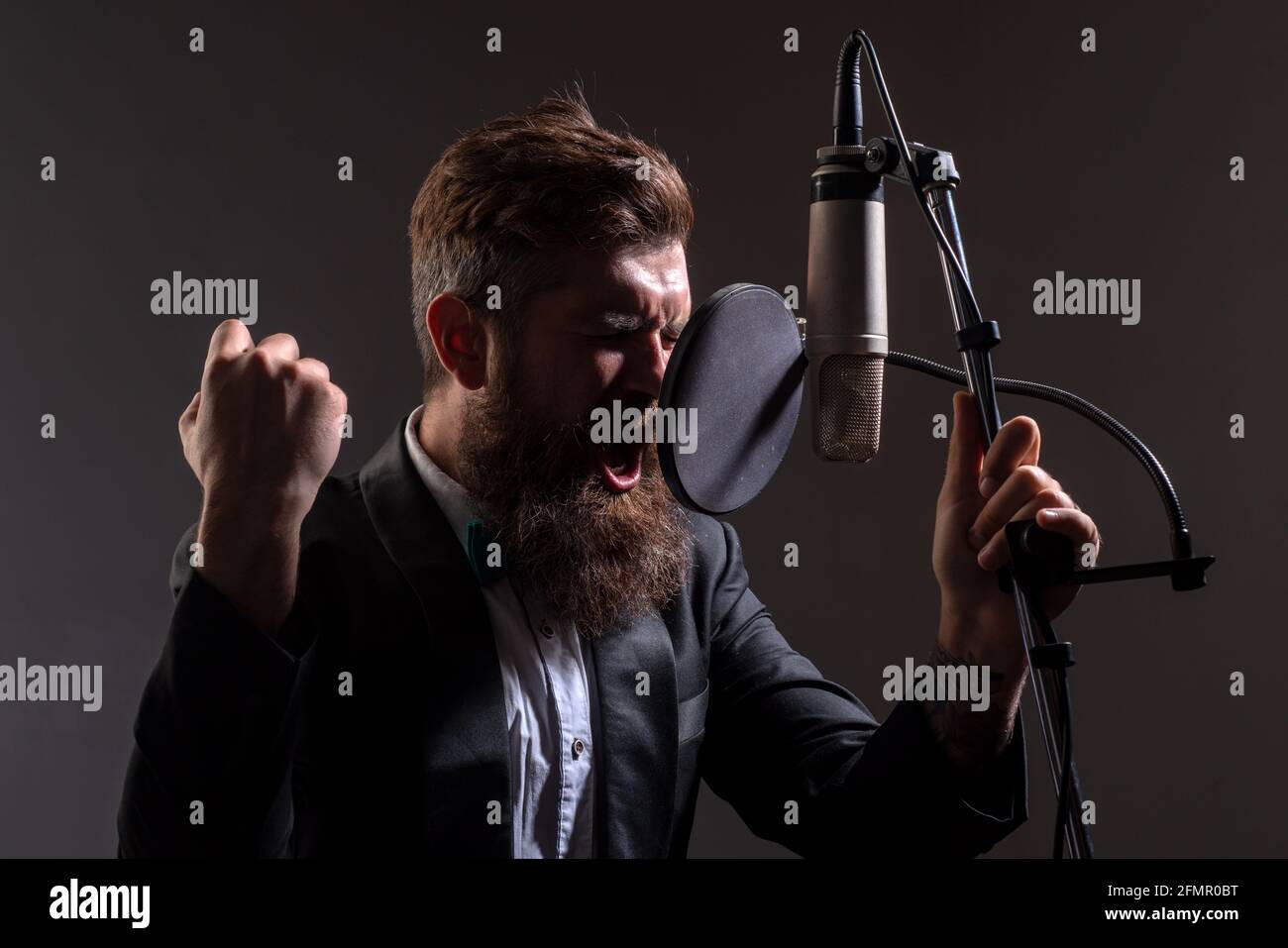 Handsome man in recording studio gestures with hands. Music performance ...