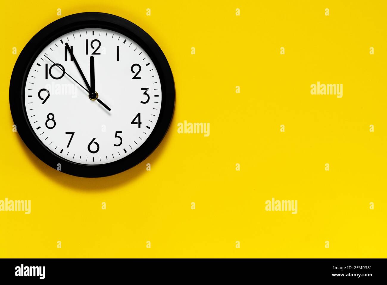 a clock on a yellow background Stock Photo - Alamy