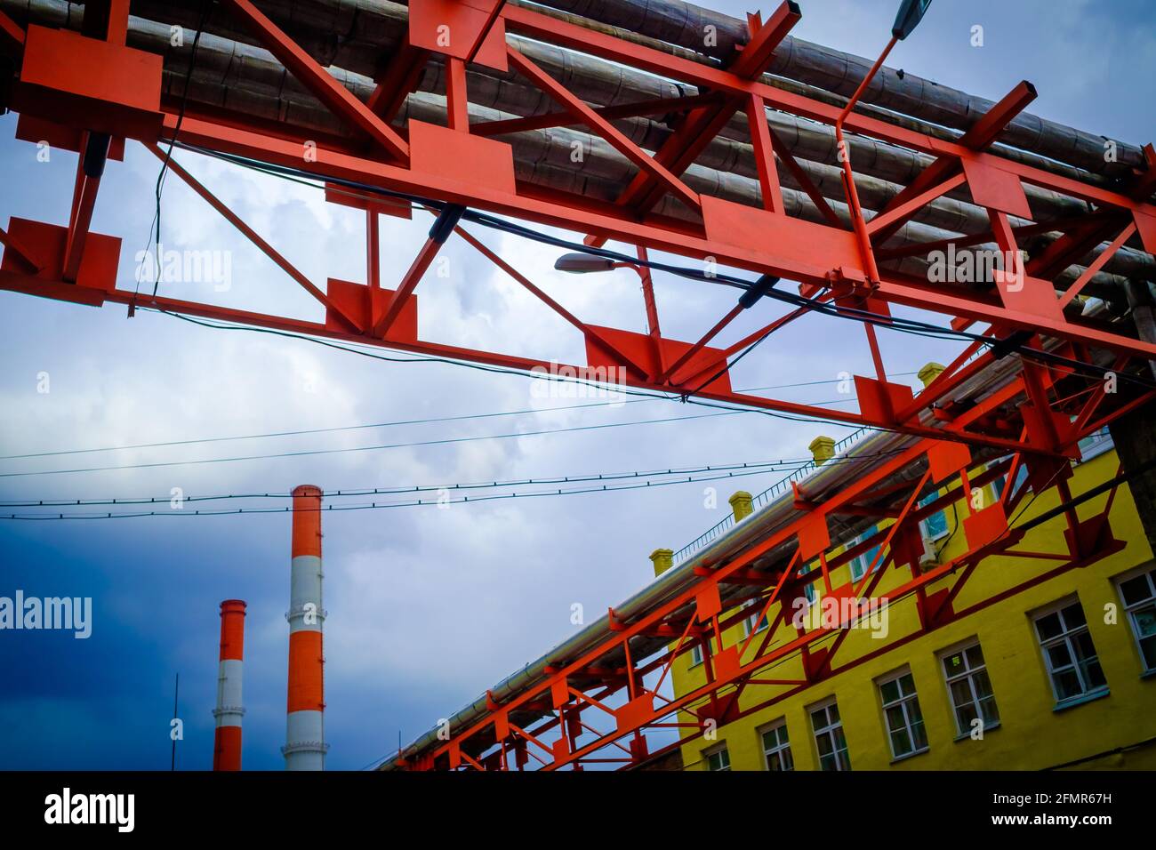 From below metal structure with pipes located near factory building and ...