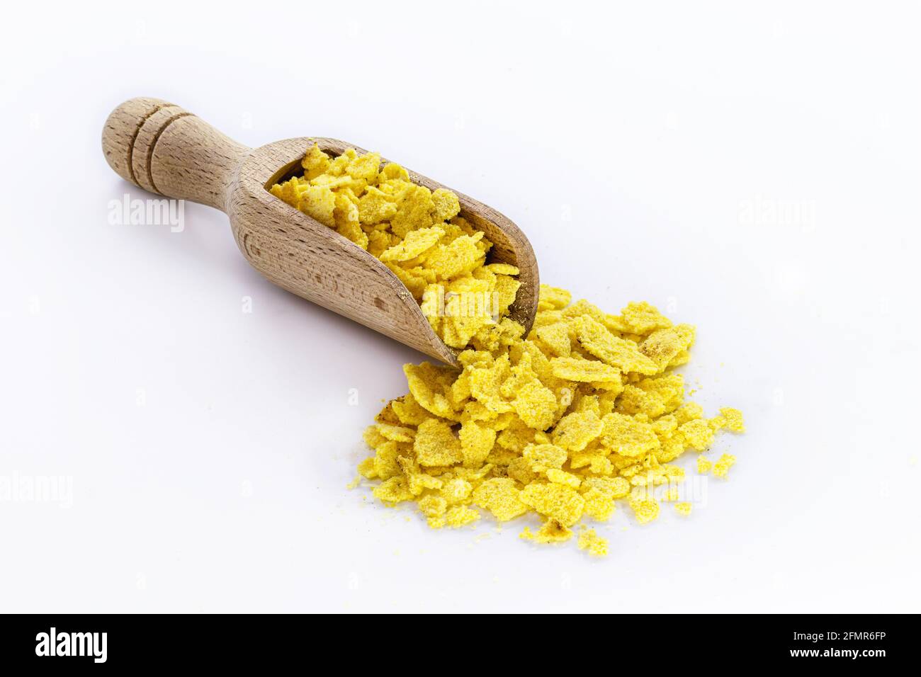 toasted cornmeal flakes in wooden measuring spoon, isolated white ...