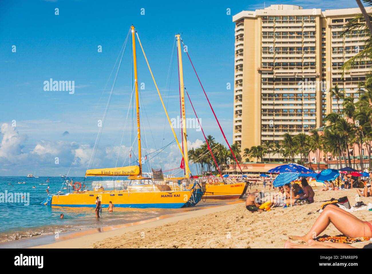 Oahu Hawaii people enjoying Waikiki beach with hotel and sailboat on ...
