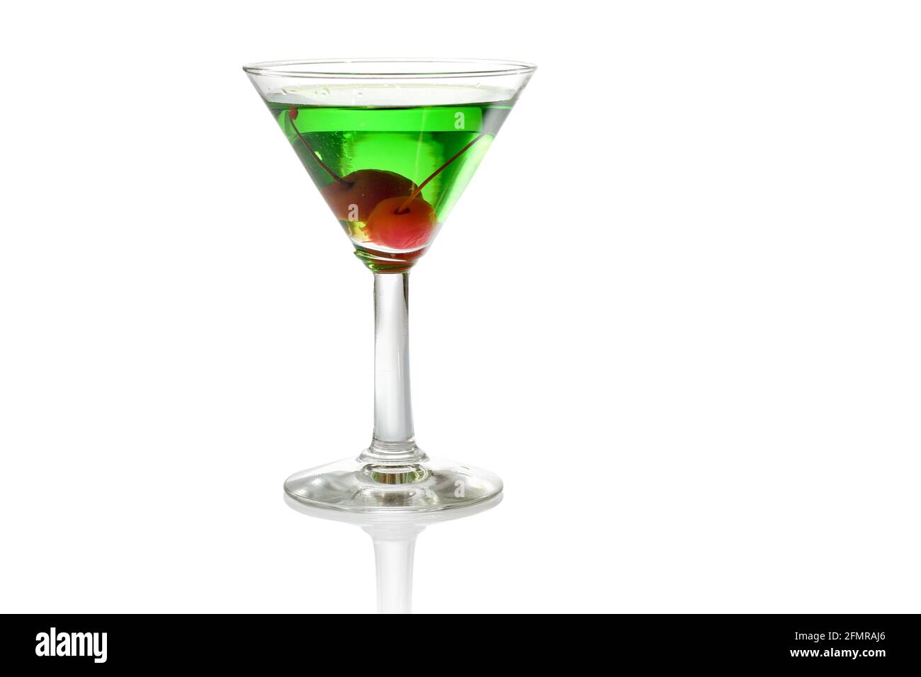 green alcoholic midori cocktail with cherries in martini glass isolated ...
