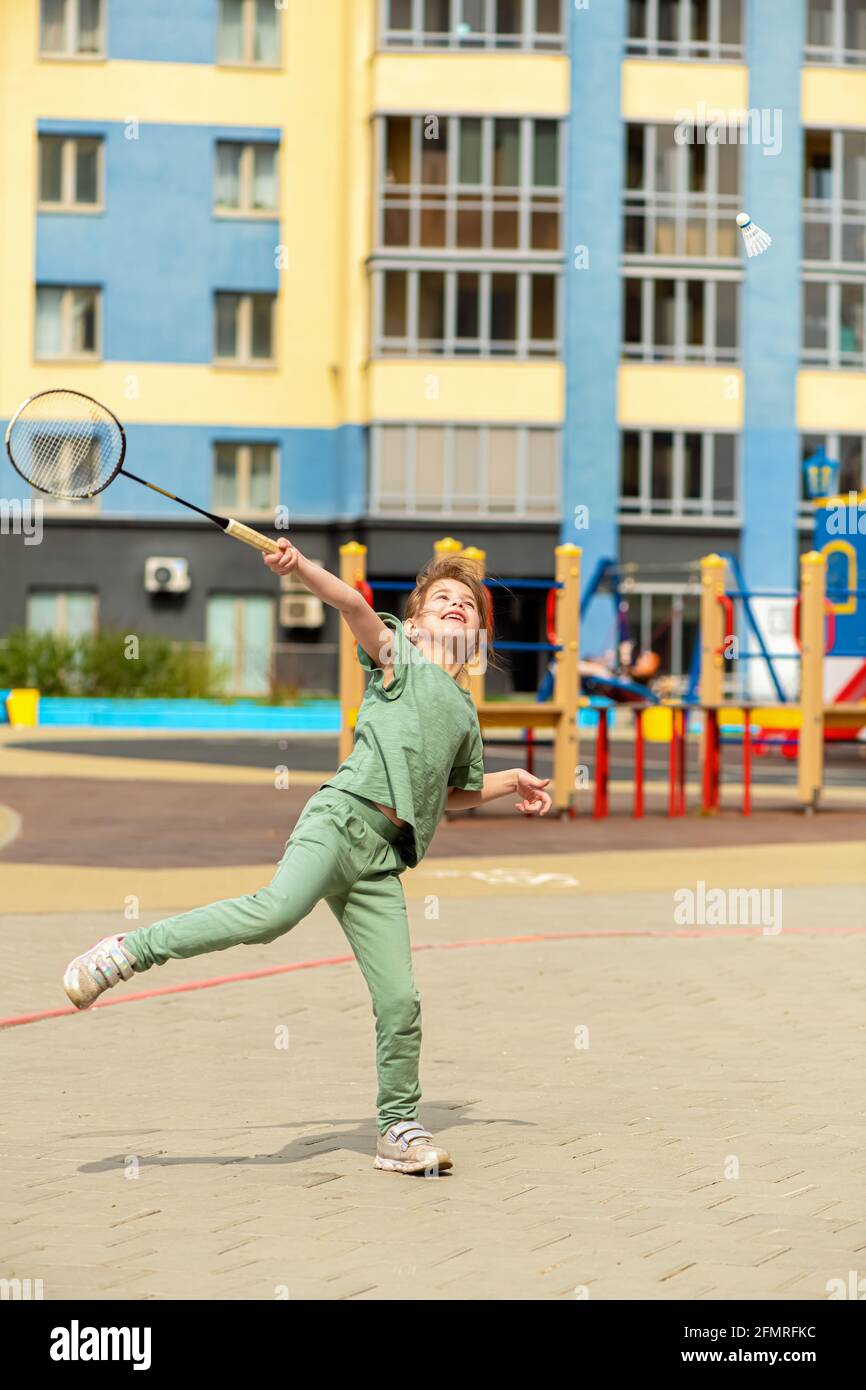 Cute little girl plays in the yard in badminton. activity, healthy ...