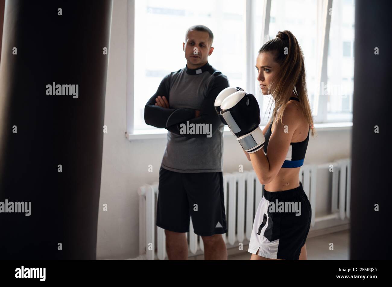Woman training boxing with personal trainer. Instructor teaching female ...