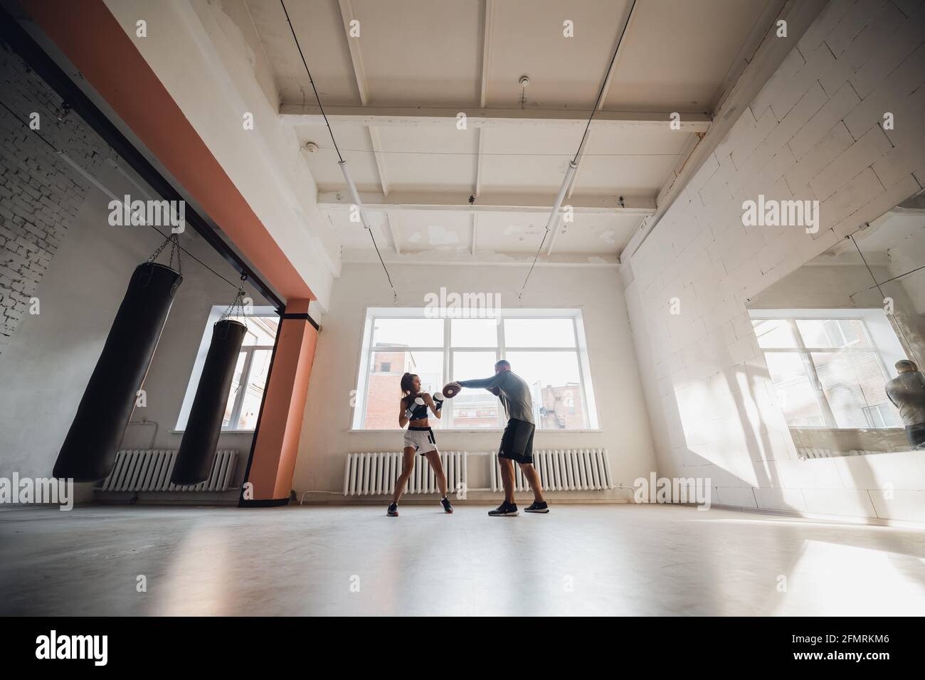 Woman training boxing with personal trainer. Instructor teaching female ...