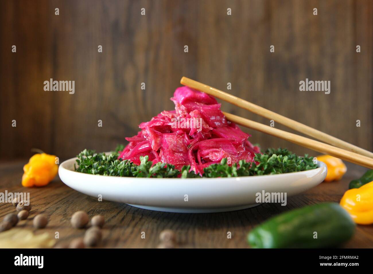 Tasty Korean cabbage salad with beets with pepper on a plate. Asian ...