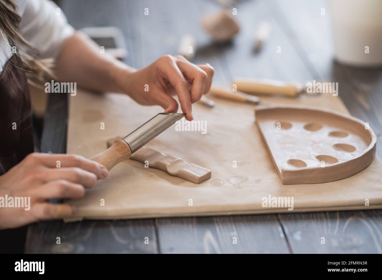 Craftsman hands connect the clay parts made of raw clay, master fingers ...