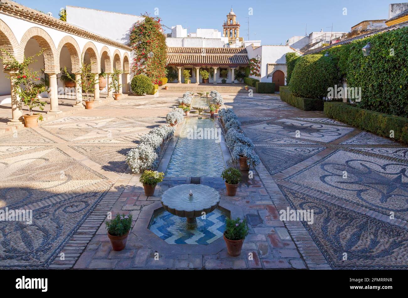 Typical Andalusian patio with fountain and numerous plants geraniums ...