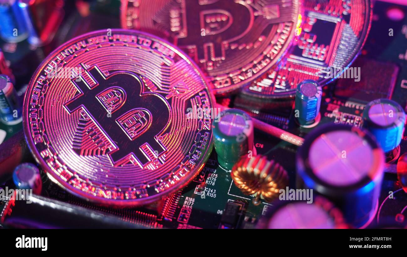 Cryptocurrency coins on circuit board. Bitcoins standing on CPU board. Close-up Bitcoin with ...