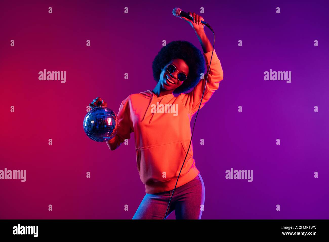 Portrait of attractive cheerful dark skin person hold disco ball mic ...