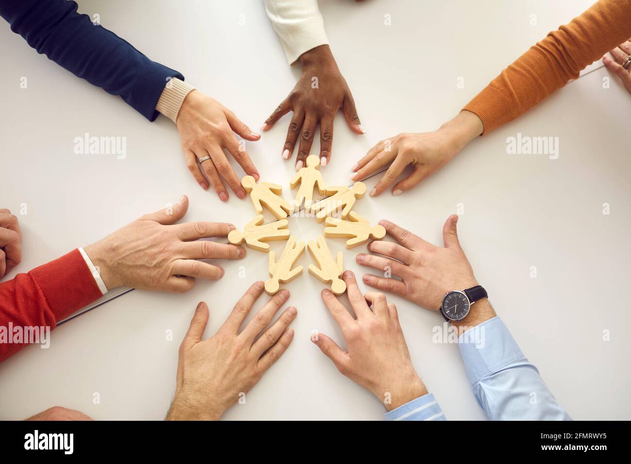 Team of business people join little human figures as symbol of teamwork ...