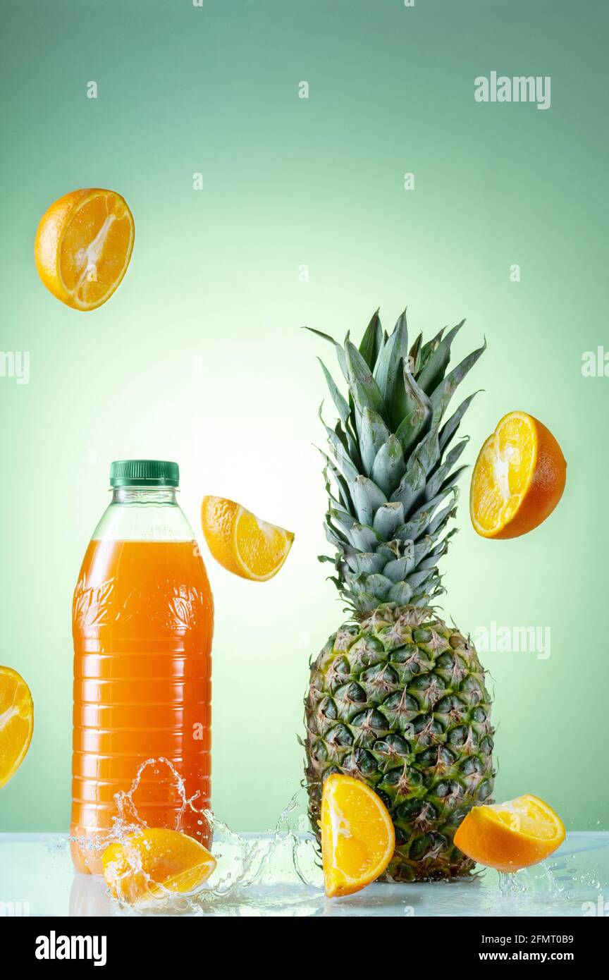 Multivitamin juice with flying fruits. Pineapple and flying orange ...