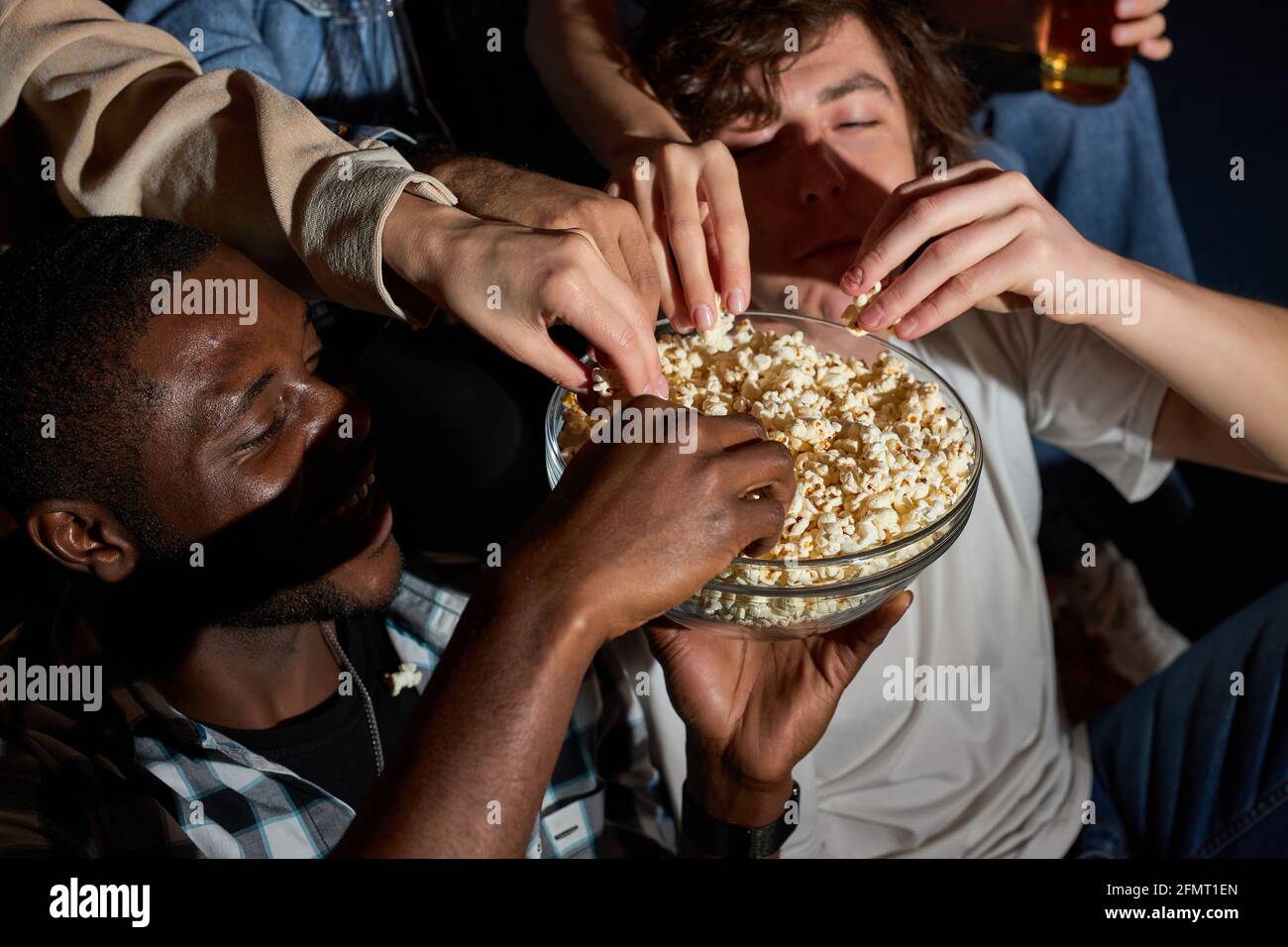 Fun Movie with Friends. Group of people eating popcorn while watching ...