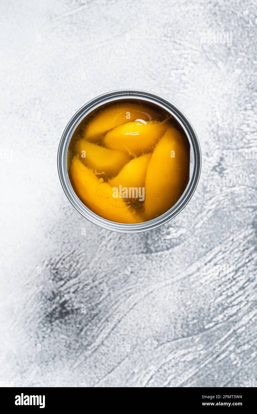 Canned mango slices in syrup in a metal can. White background. Top view ...