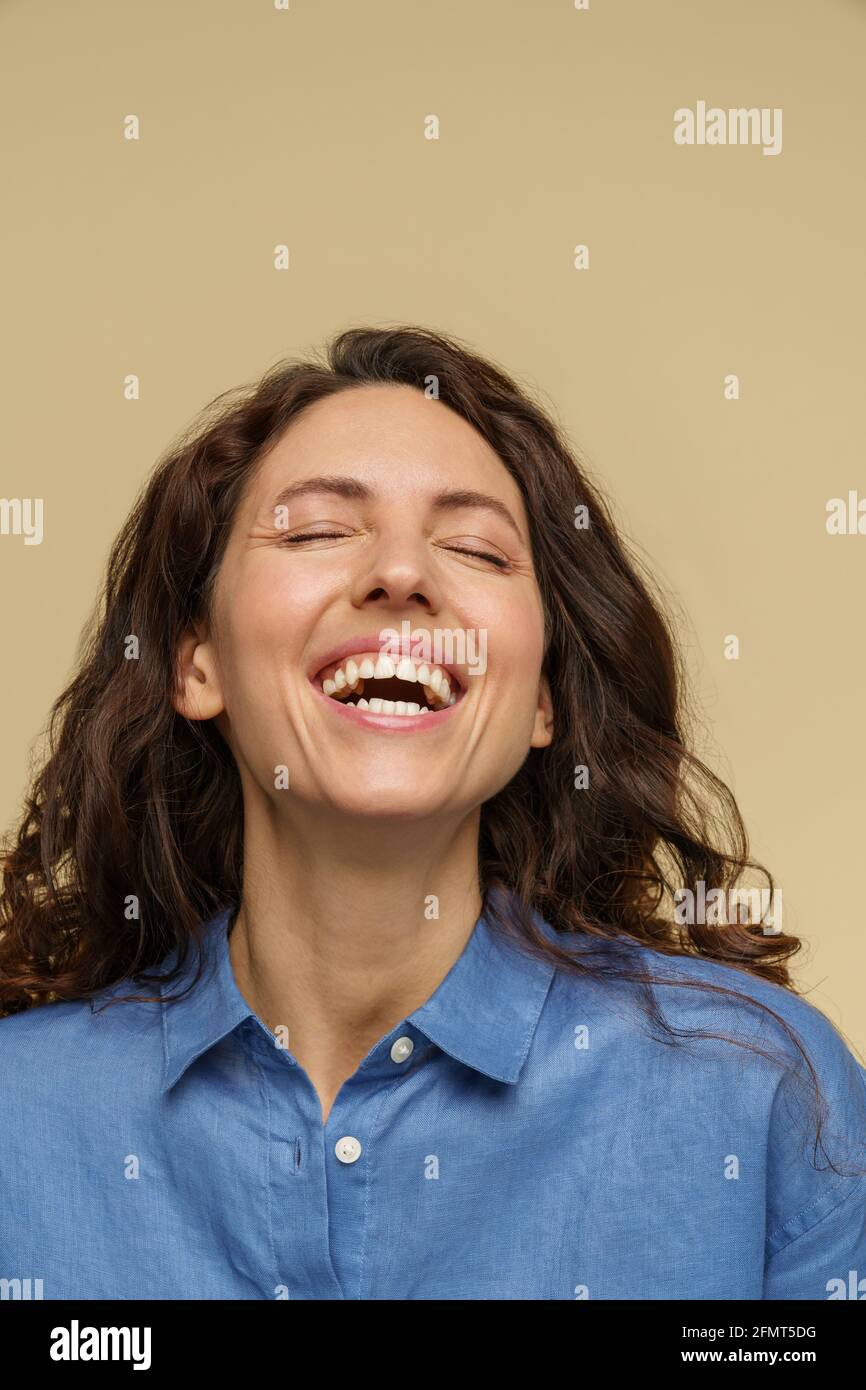 Excited overjoyed curly girl isolated on beige background laugh with ...