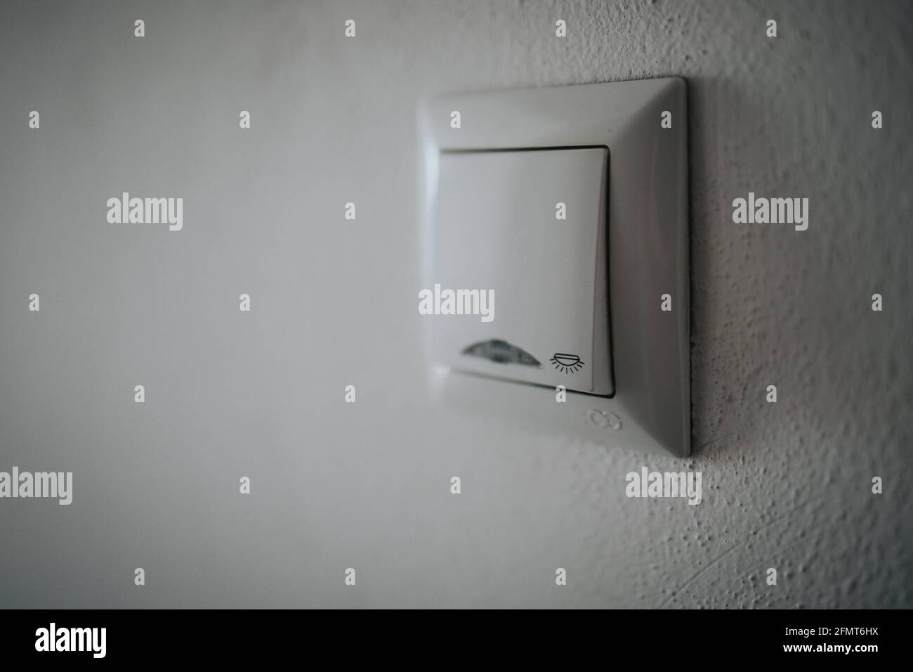 Selective focus shot of a simple light switch on a plain white wall ...