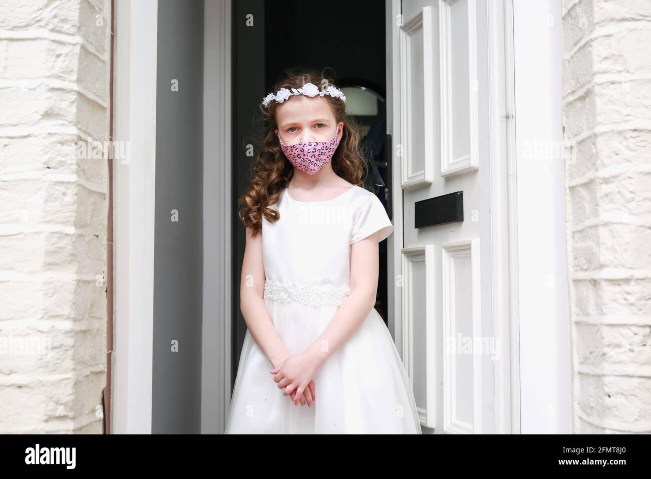 London, UK. 09 May 2021. A girl during her First Holy Communion wearing ...