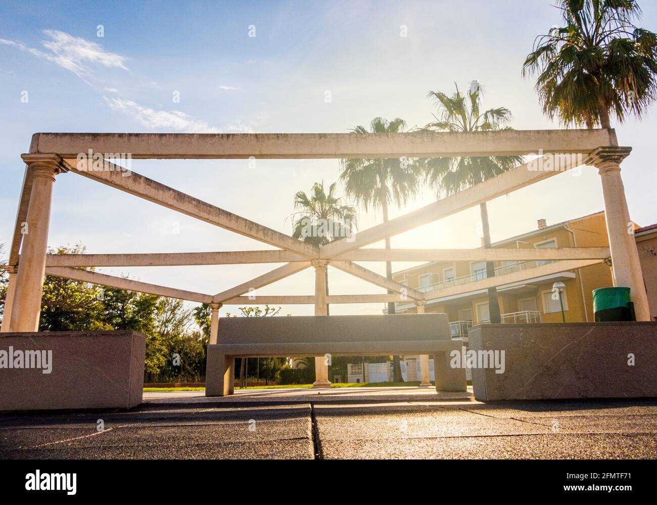 Bench near decorative pillars surrounded by greenery in a park under ...