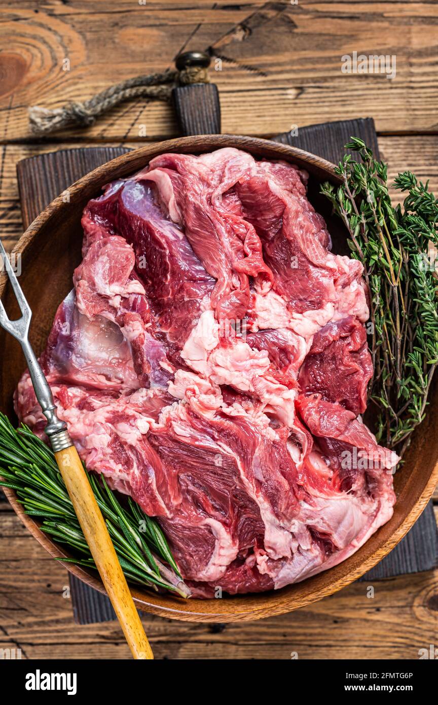 Boneless raw mutton Lamb Shoulder meat in wooden plate with herbs ...