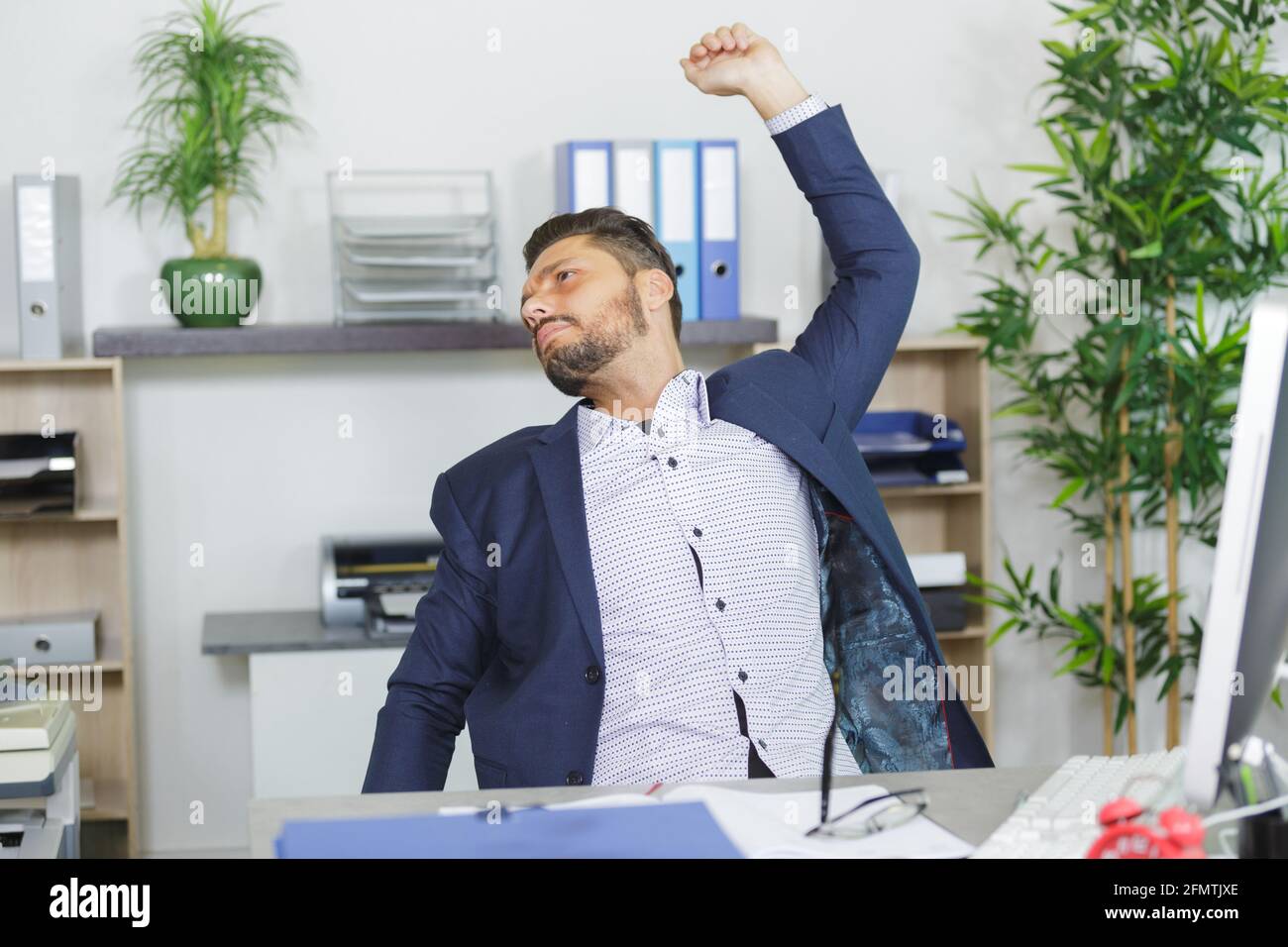 young businessman stretching in the office Stock Photo - Alamy