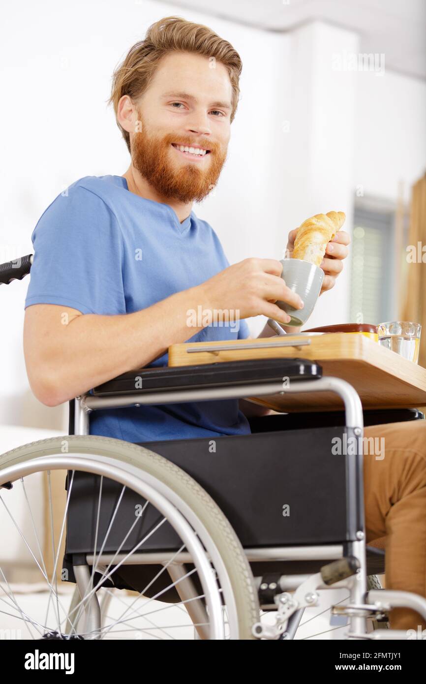 man in wheelchair is ready to have food at home Stock Photo - Alamy