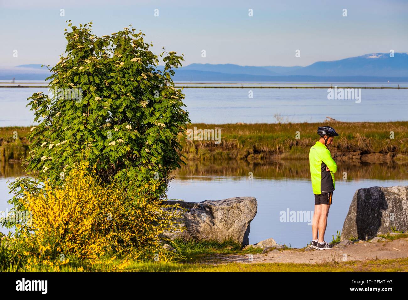 Cyclist in pensive mood looking at his shadow at Gary Point Park in ...