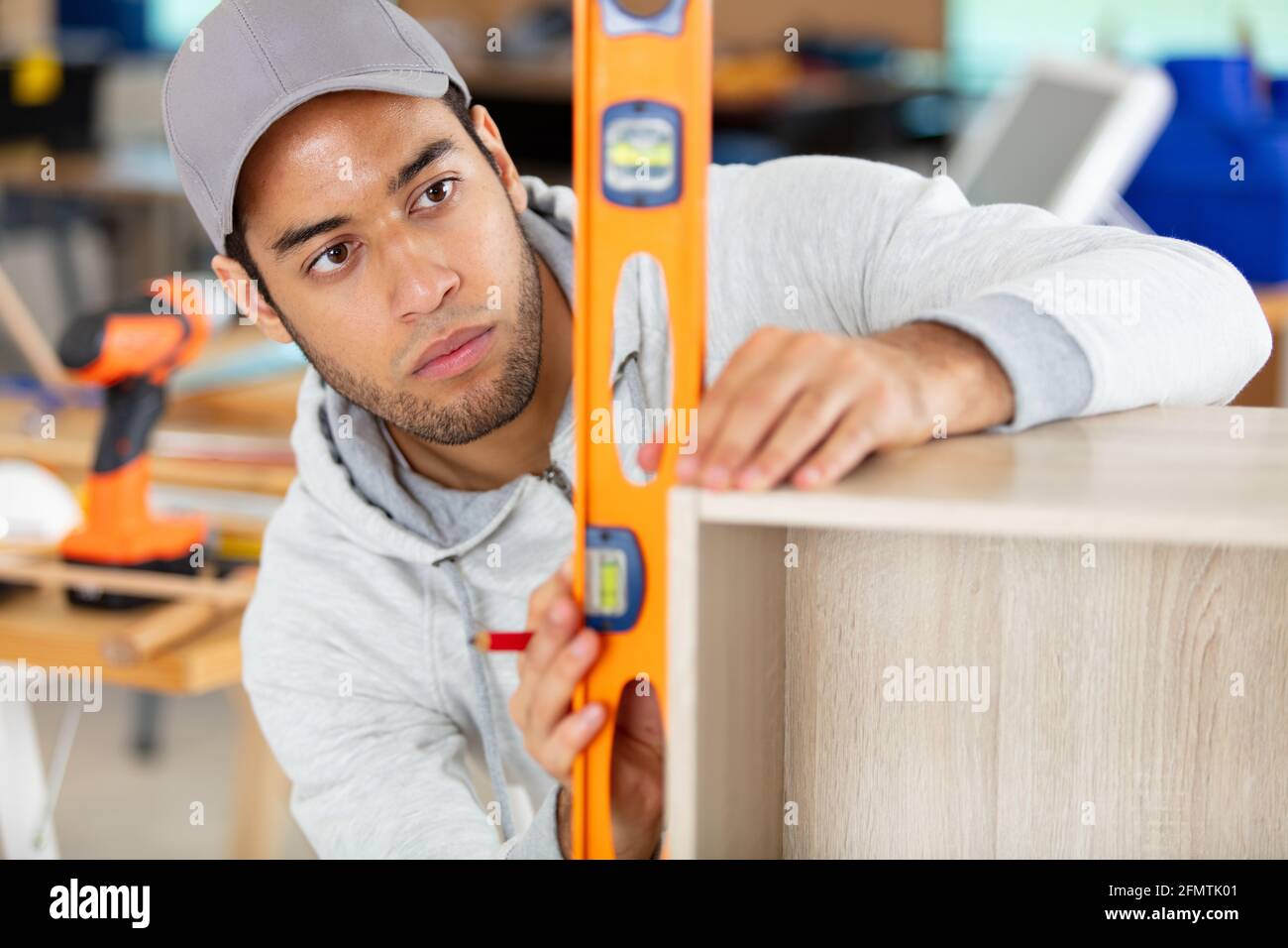 carpenter using spirit level for leveling assembled furniture Stock ...