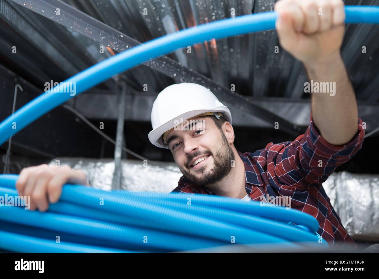 happy man installing pipes indoors Stock Photo - Alamy