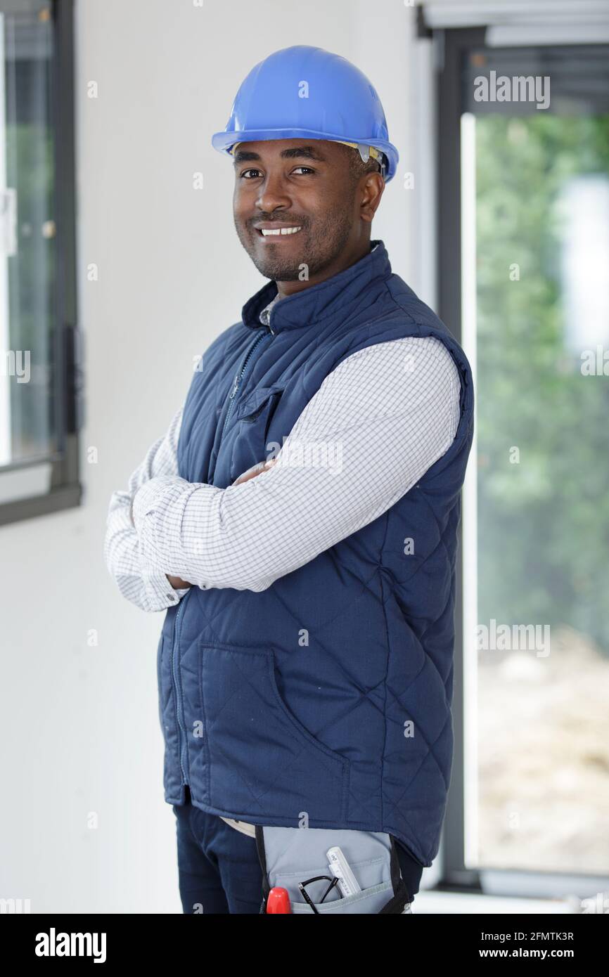 jolly smiling constructor folding arms Stock Photo - Alamy