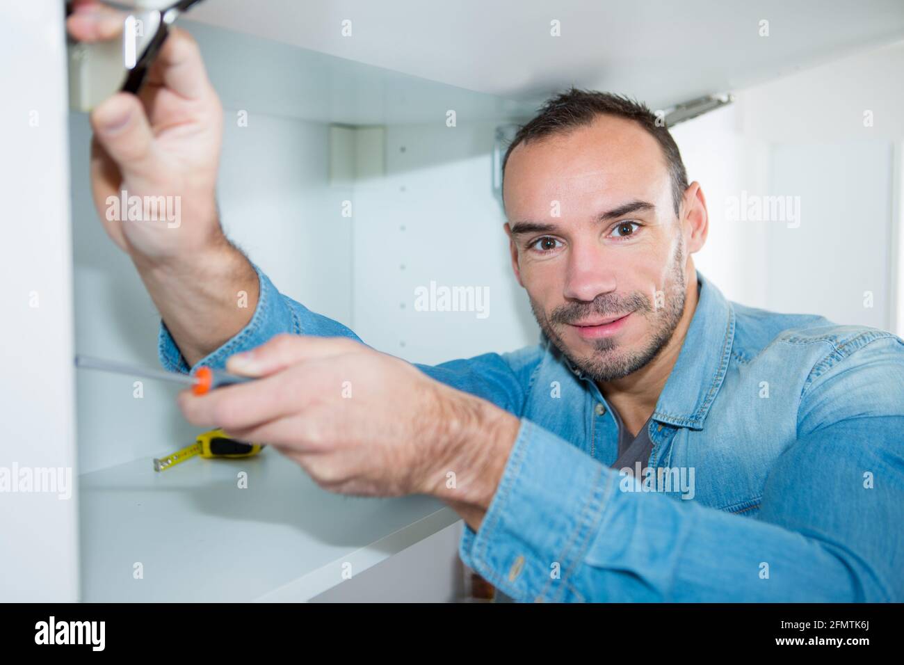 handyman fixing a wardrobe Stock Photo - Alamy