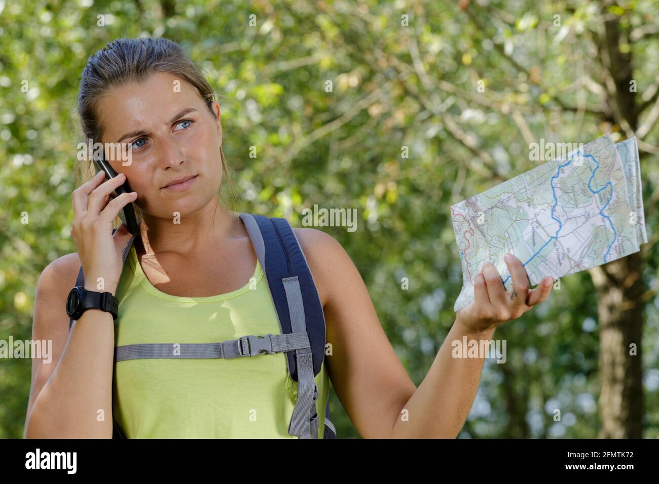 female rambler holding map and talking on smartphone Stock Photo - Alamy