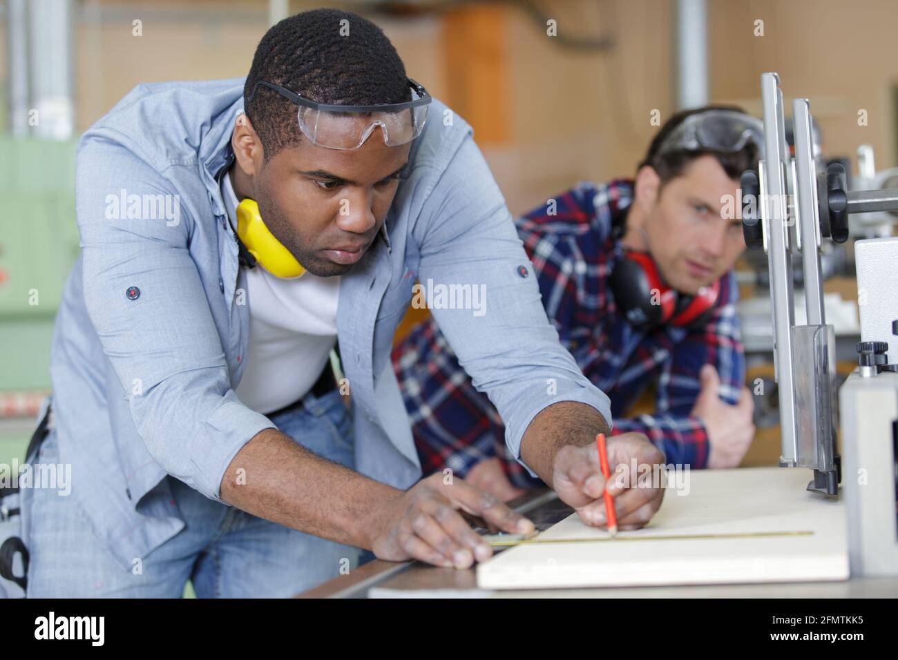 foreman watching apprentice carpenter at work Stock Photo - Alamy