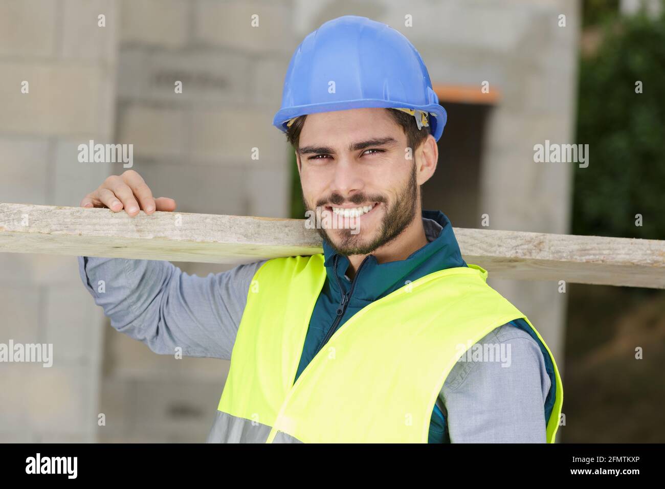 male carpenter with wooden plank at construction site Stock Photo - Alamy