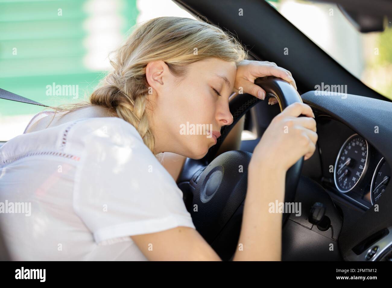 young woman asleep slumped over the wheel of her car Stock Photo - Alamy