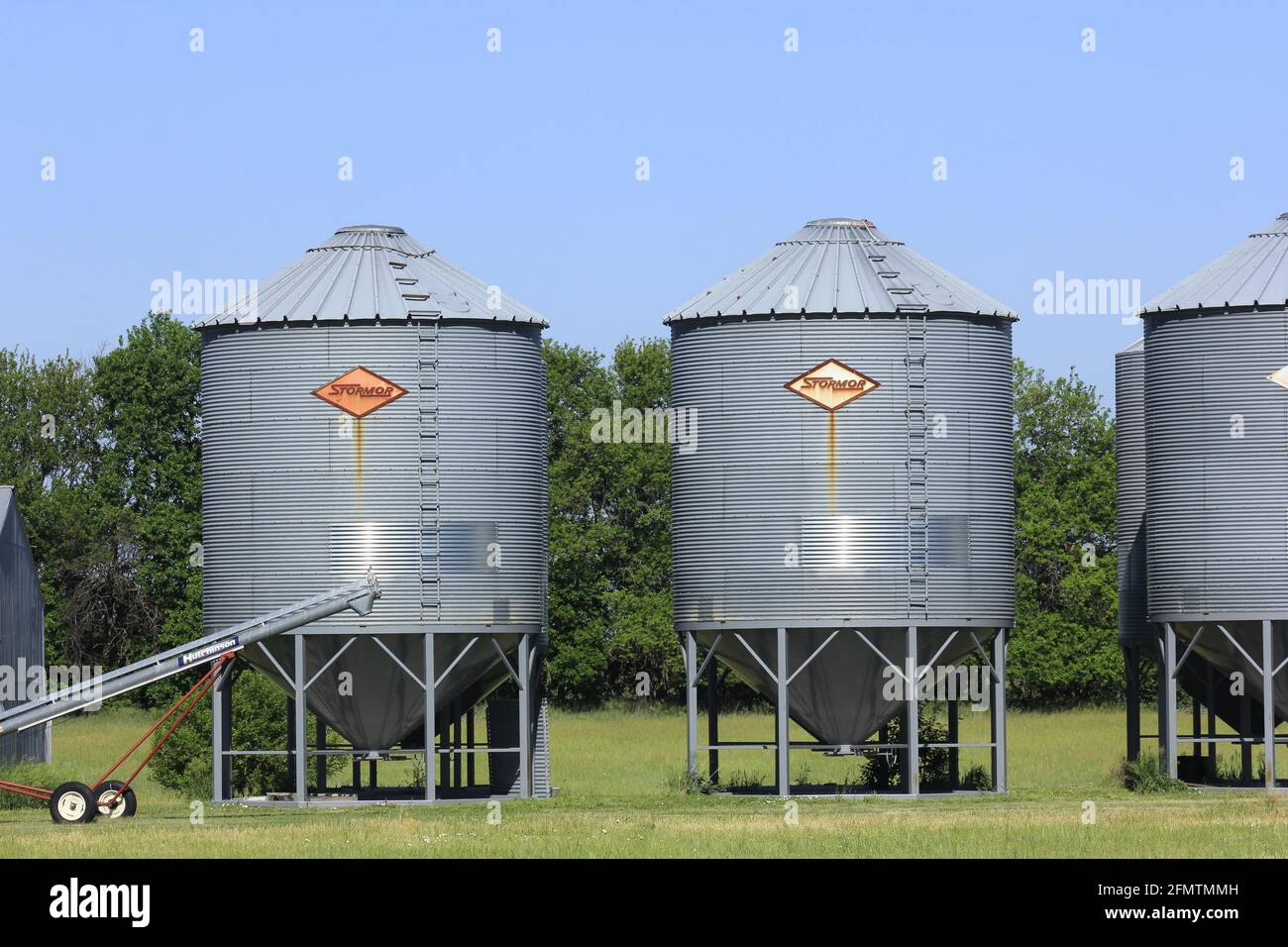 Kansas Country Grain Bins with blue sky, green grass, and tree's that ...