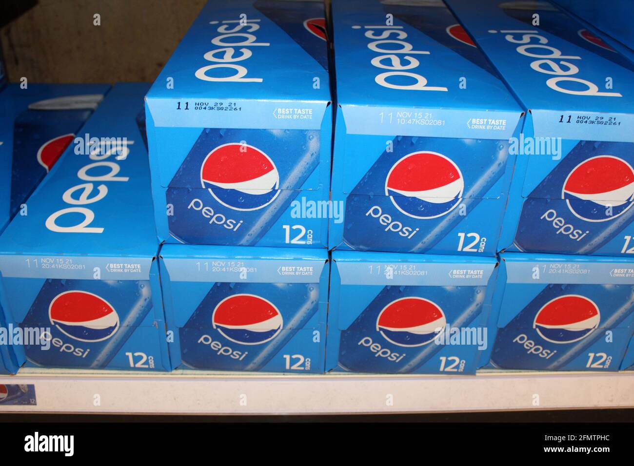 Pepsi in carton's that's bright and colorful on a metal shelf at a ...