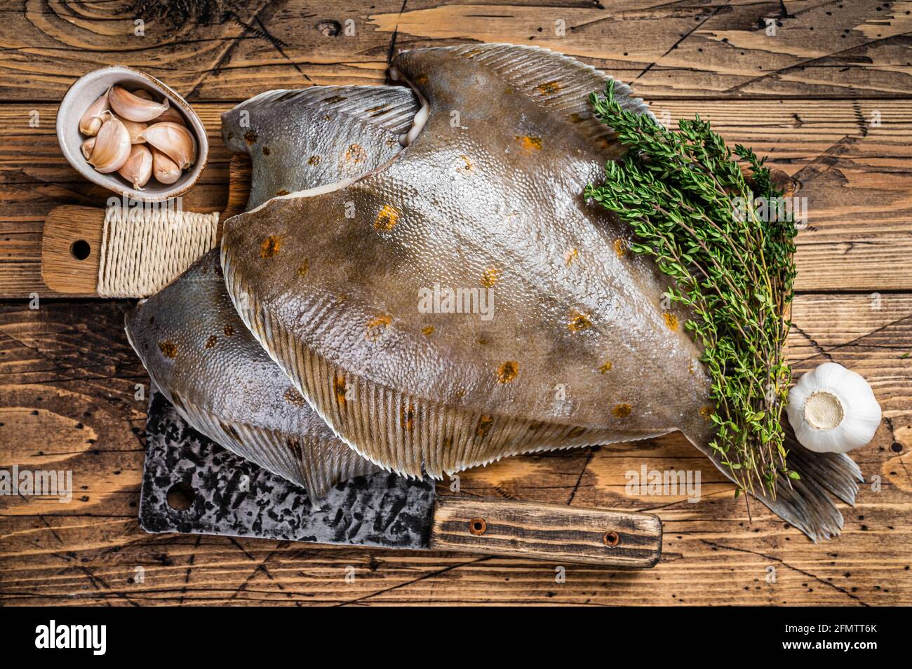 Raw flounder flatfish on butcher board with cleaver. wooden background ...