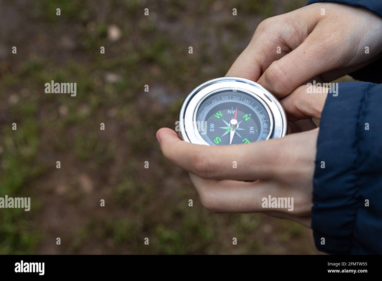 Selective focus of a detail of a girl's hands holding a compass for ...