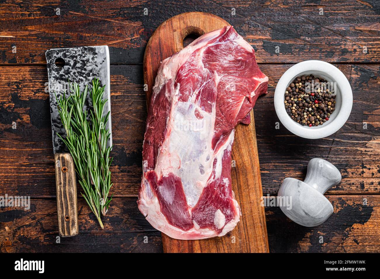 Raw lamb mutton shoulder meat on the bone on a wooden butcher cutting ...