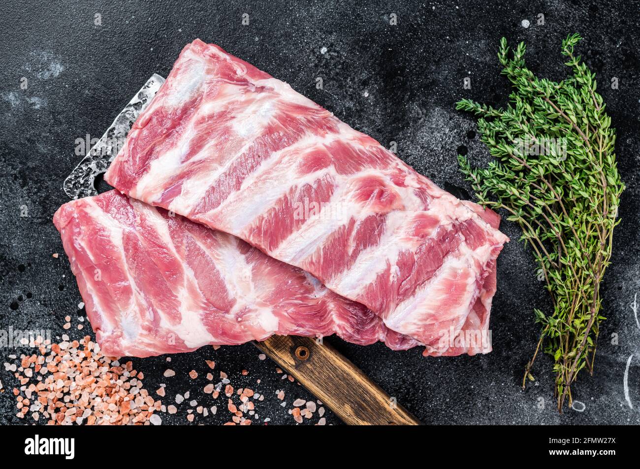 Uncooked Raw pork spare ribs on butcher meat cleaver. Black background ...