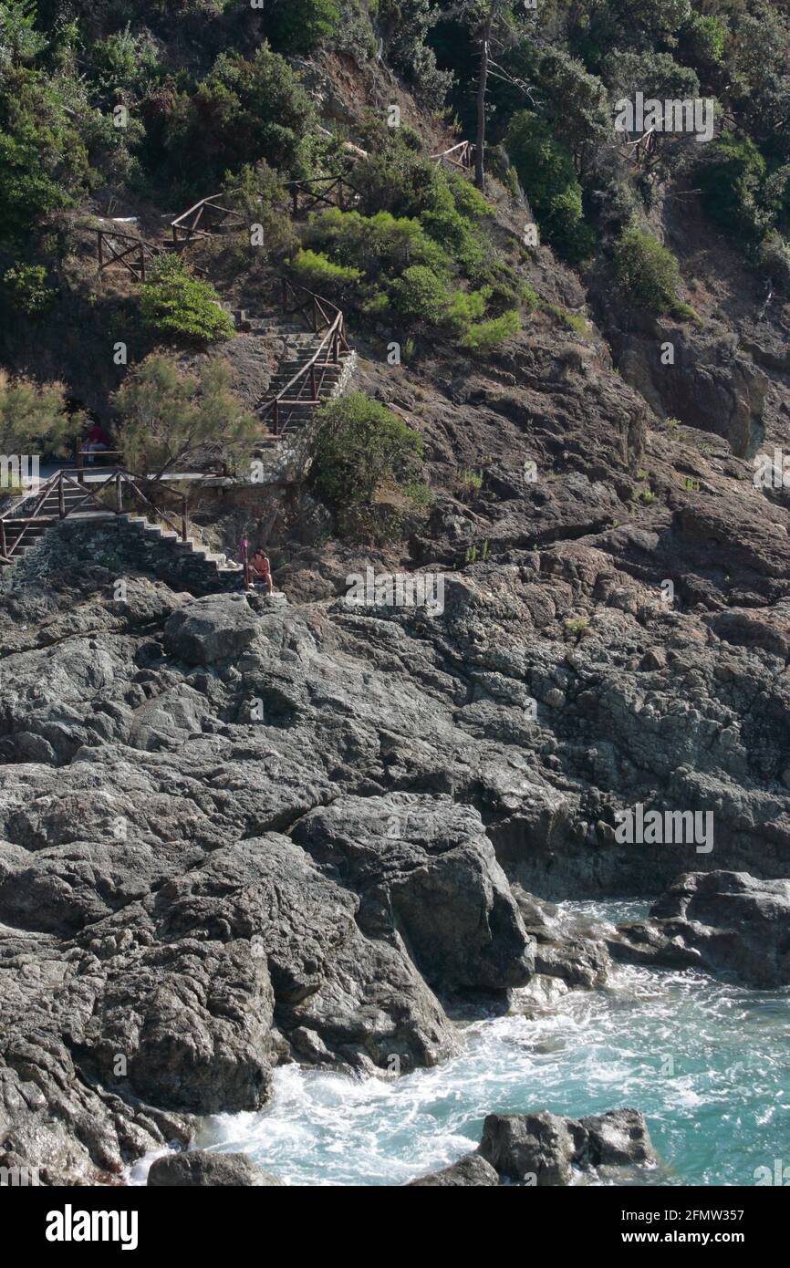 Rocky coastal cliff with stairs going into the shore Stock Photo - Alamy